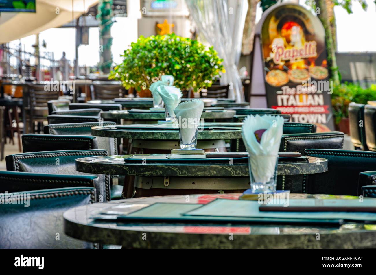Tables in a restaurant setup with napkins and menus ready for customers ...