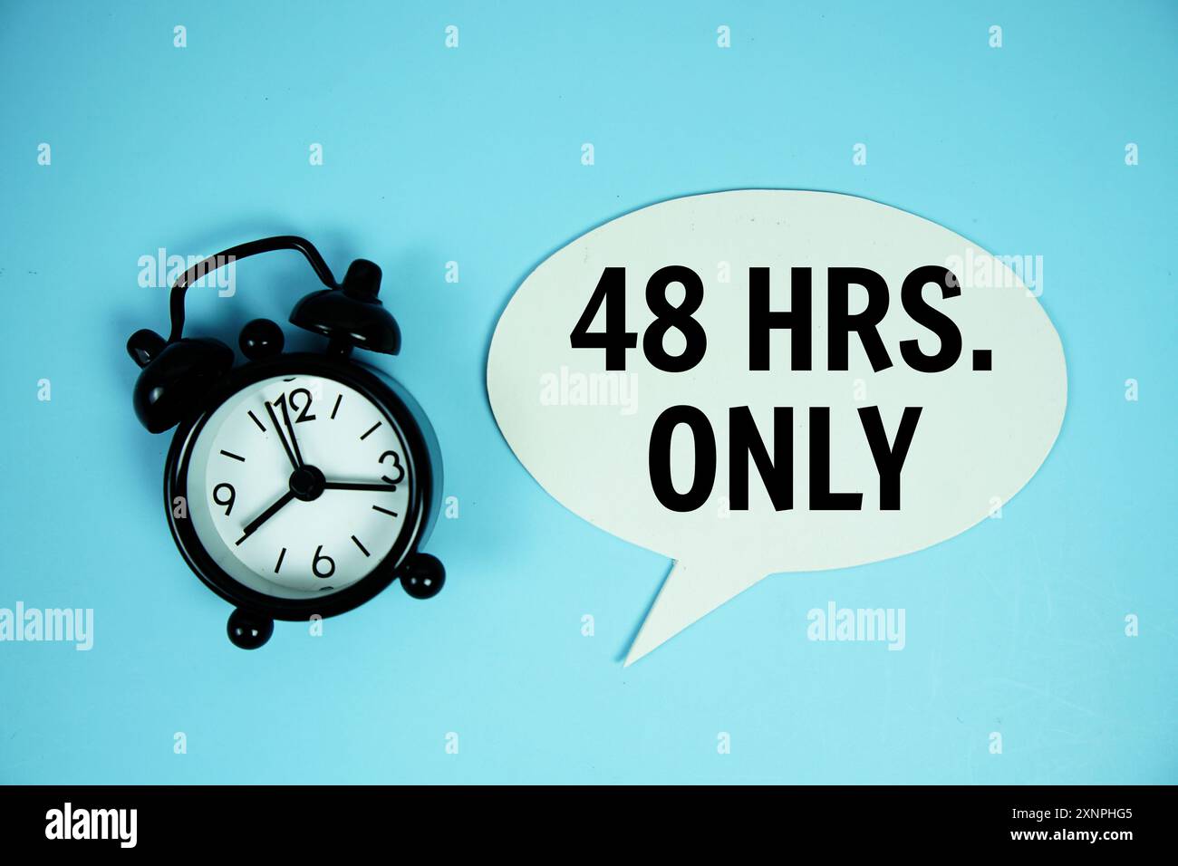 48 Hrs only text on speech bluble with alarm clock top view on blue ...