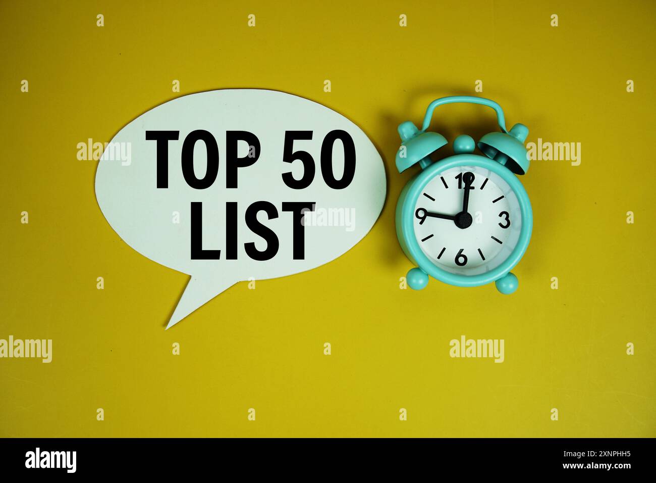 Top 50 list text on speech bluble with alarm clock top view on yellow ...