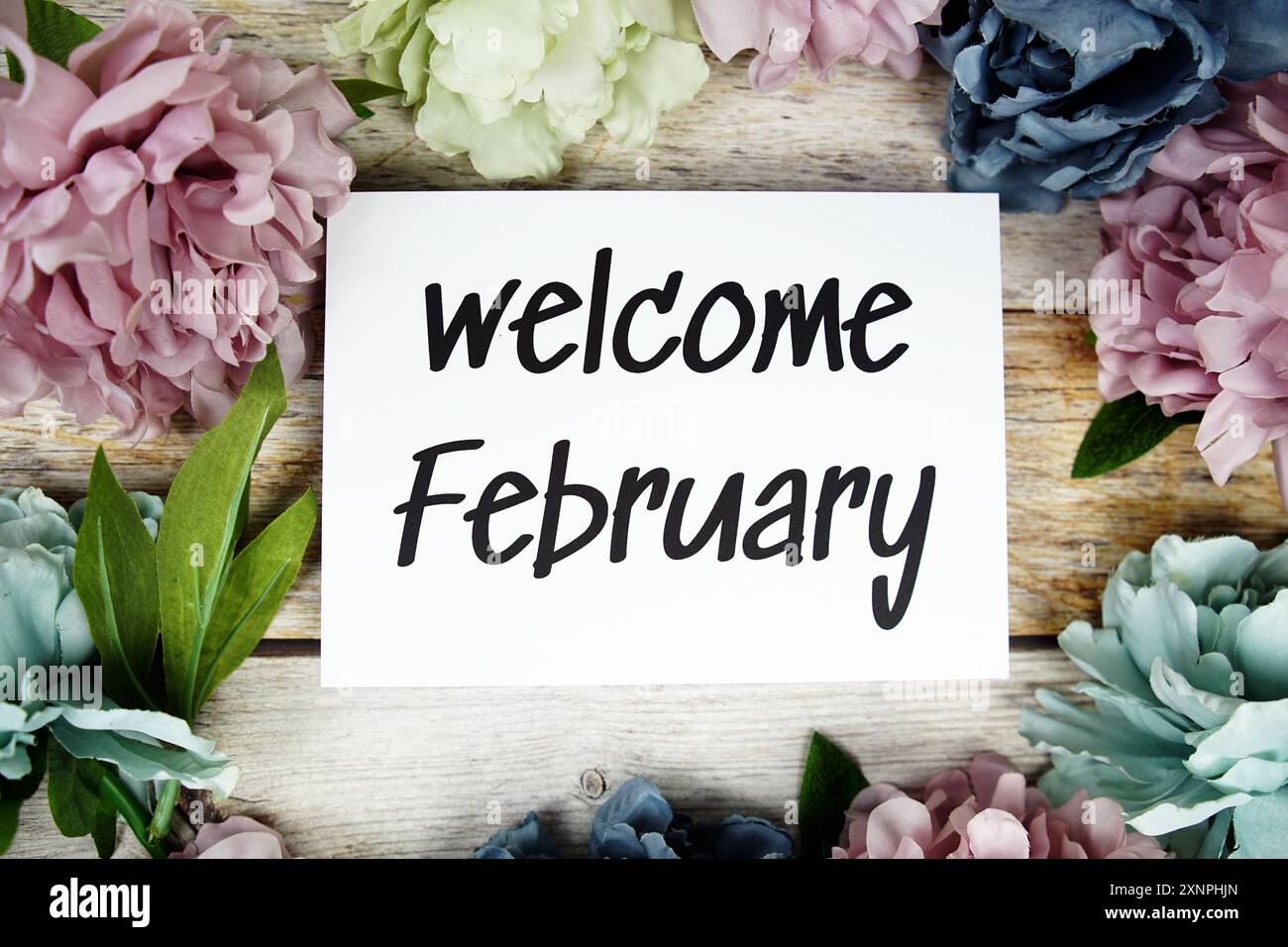 Welcome February text on paper card with flowers frame top view on ...