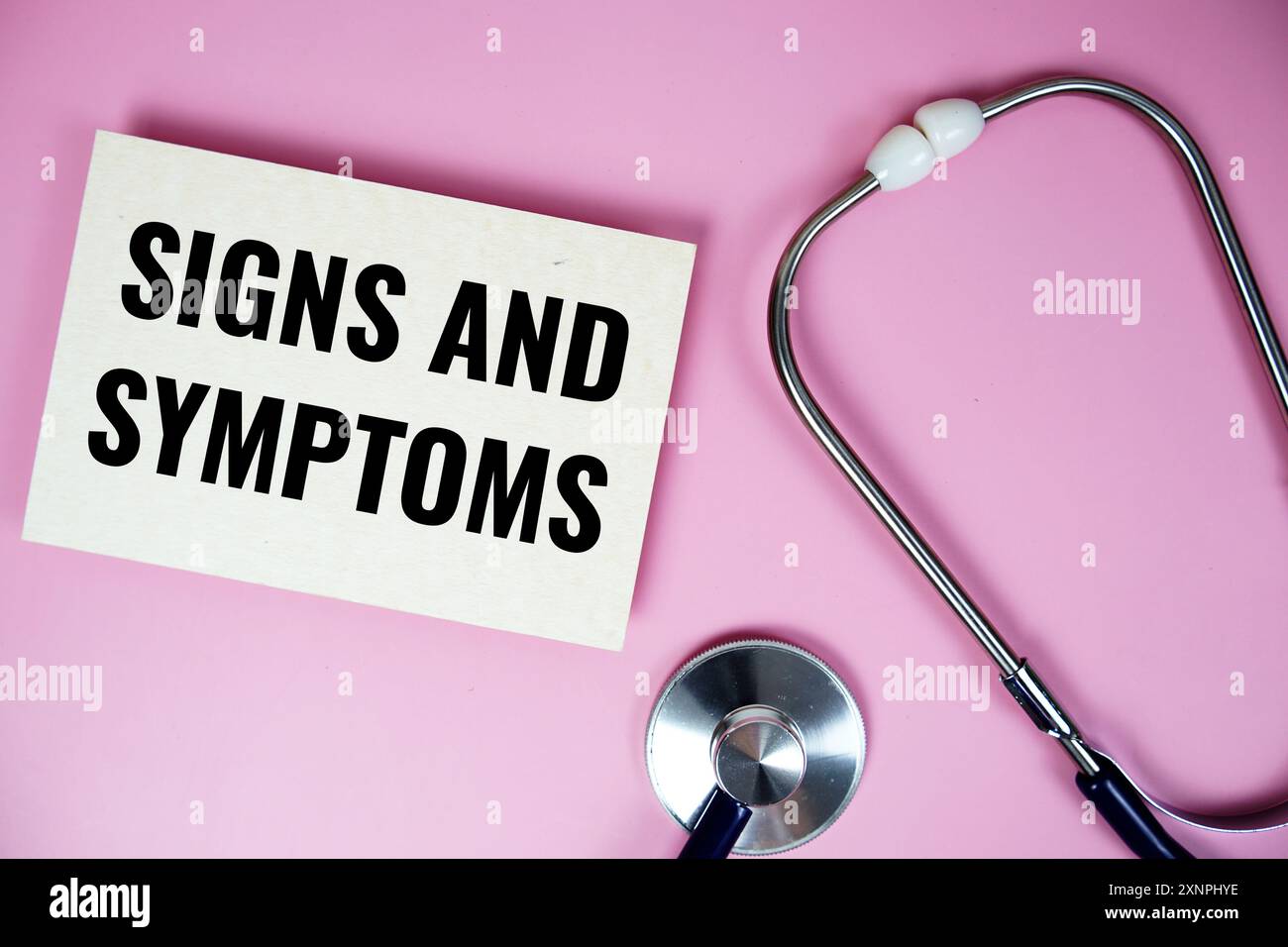 Signs and Symptoms text with stethoscope top view on pink background ...