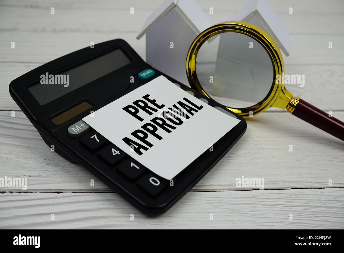 Pre-approval text message with house model, calculator and magnifying glass on wooden background ...