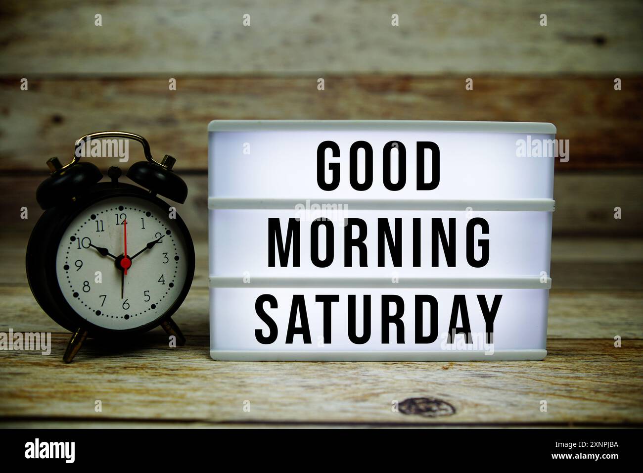 Good Morning Saturday text on LED lightbox with alarm clock on wooden ...