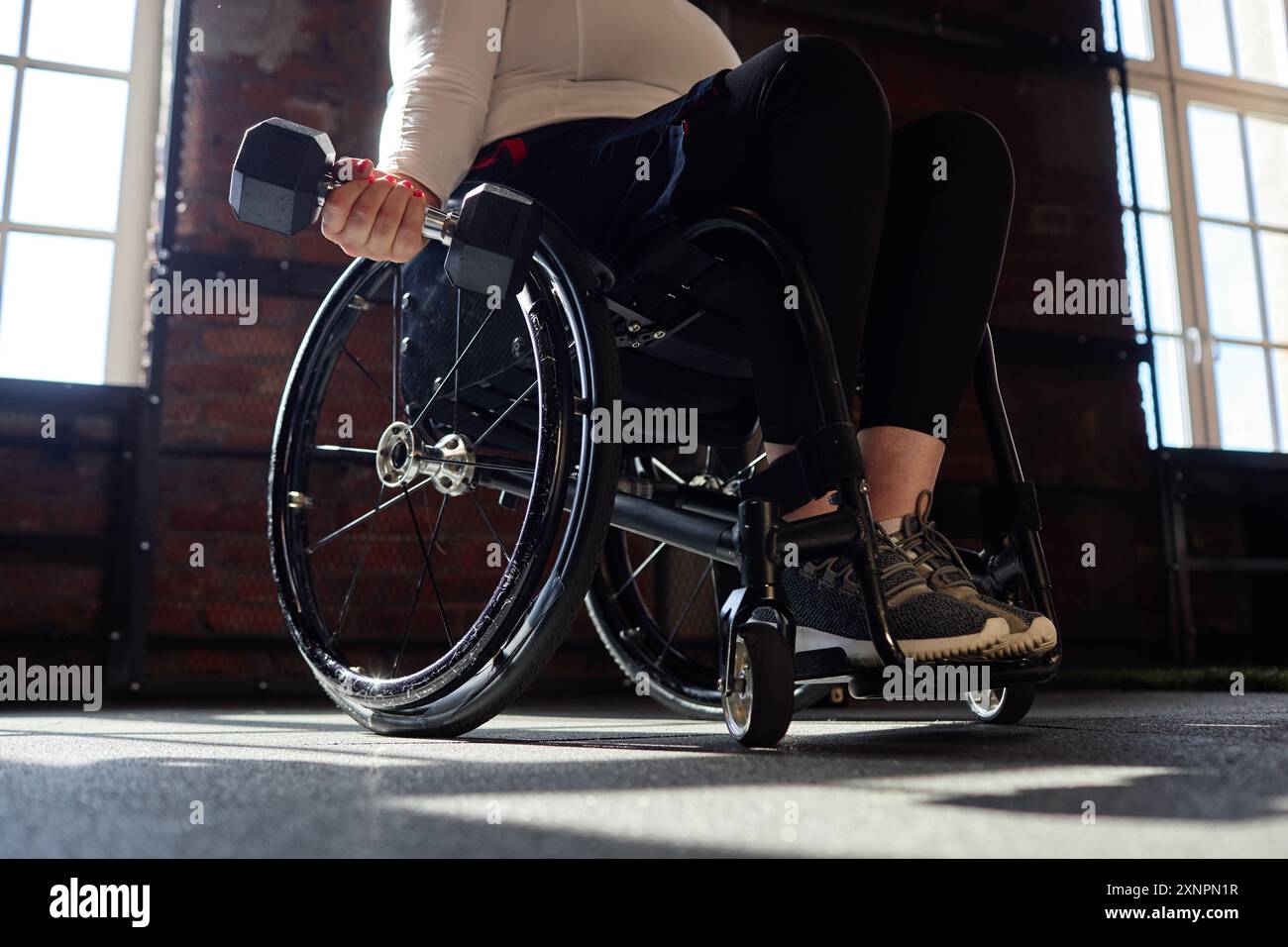 Motivational closeup of woman using wheelchair in gym and holding ...