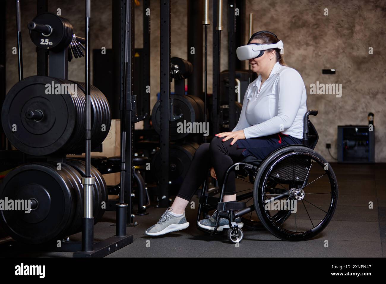 Side view portrait of woman with disability using wheelchair in gym and ...
