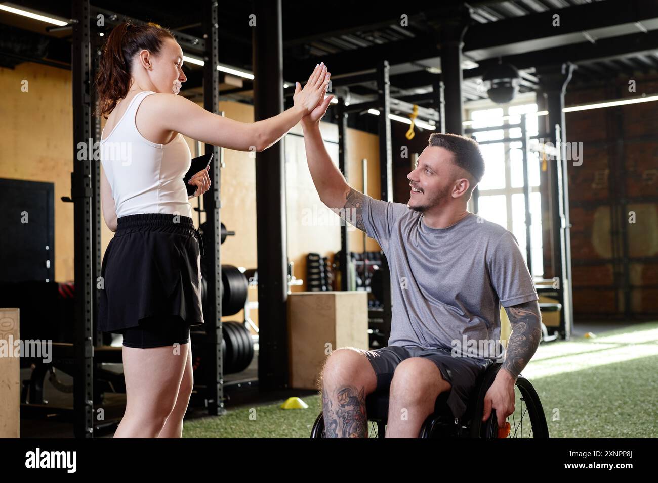Side view portrait of young man with disability high five with female ...