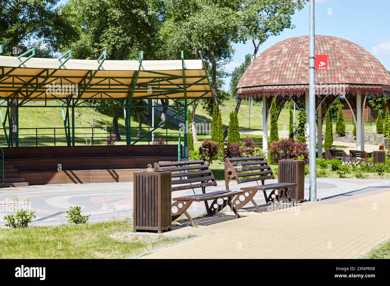 Rest area with bench surrounded by blooming trees and ornamental shrubs ...