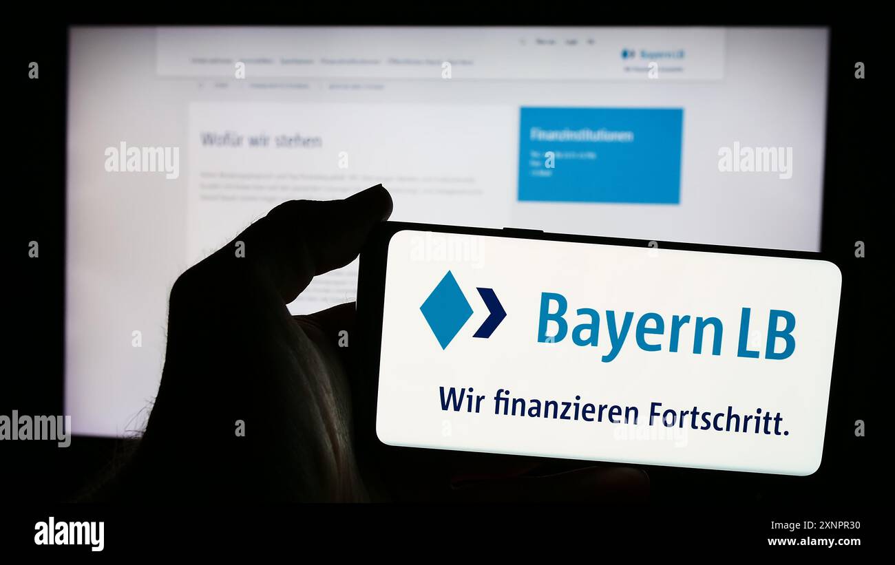 Person holding smartphone with logo of German financial company ...