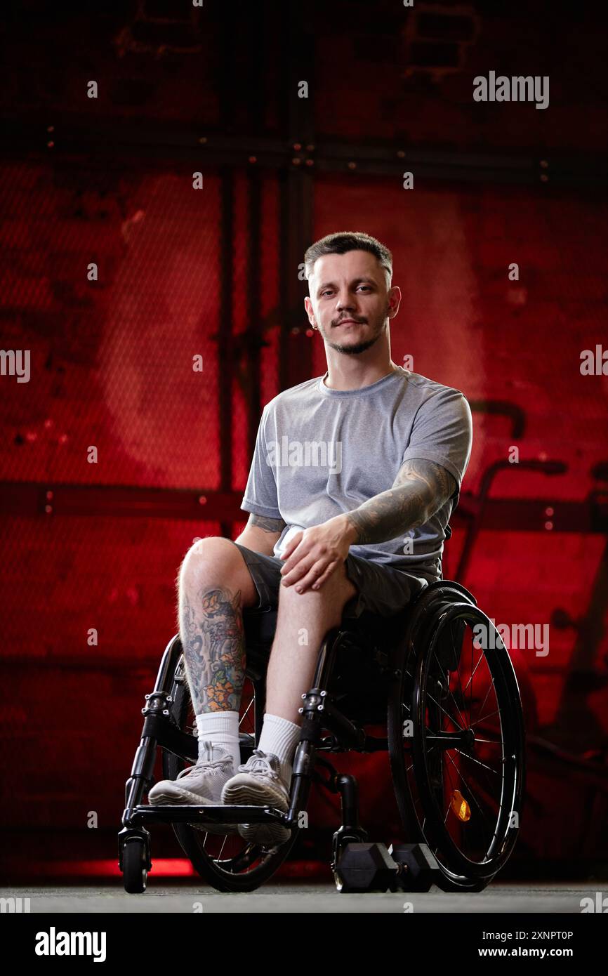 Vertical full length portrait of tattooed man with disability looking ...