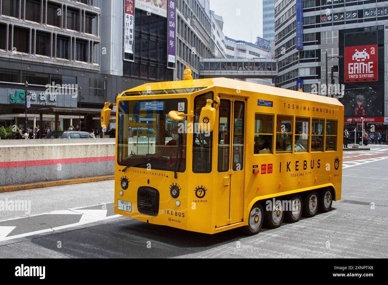 A bright yellow IIKEBUS electric tour vehicle in Ikebukuro, Tokyo ...
