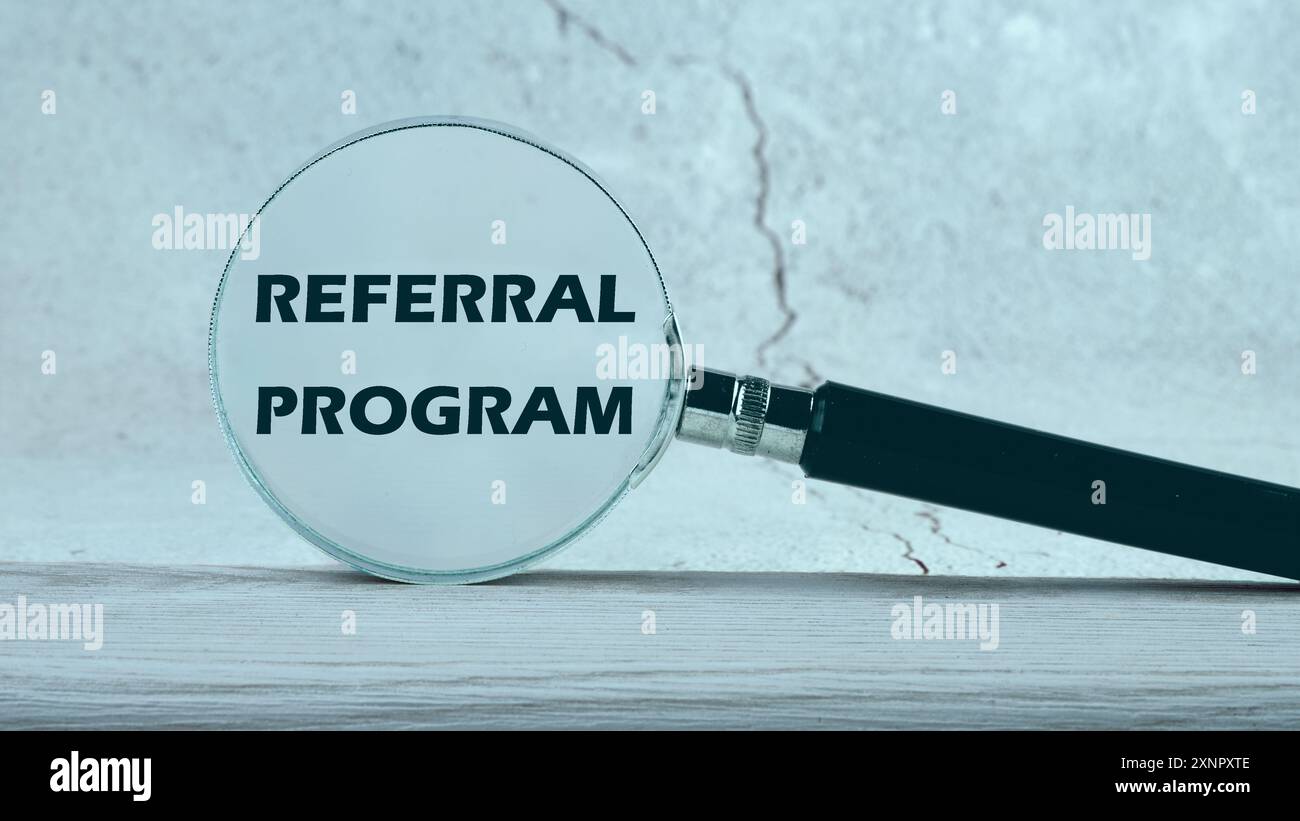 Business concept. Text REFERRAL PROGRAM through a magnifying glass on ...