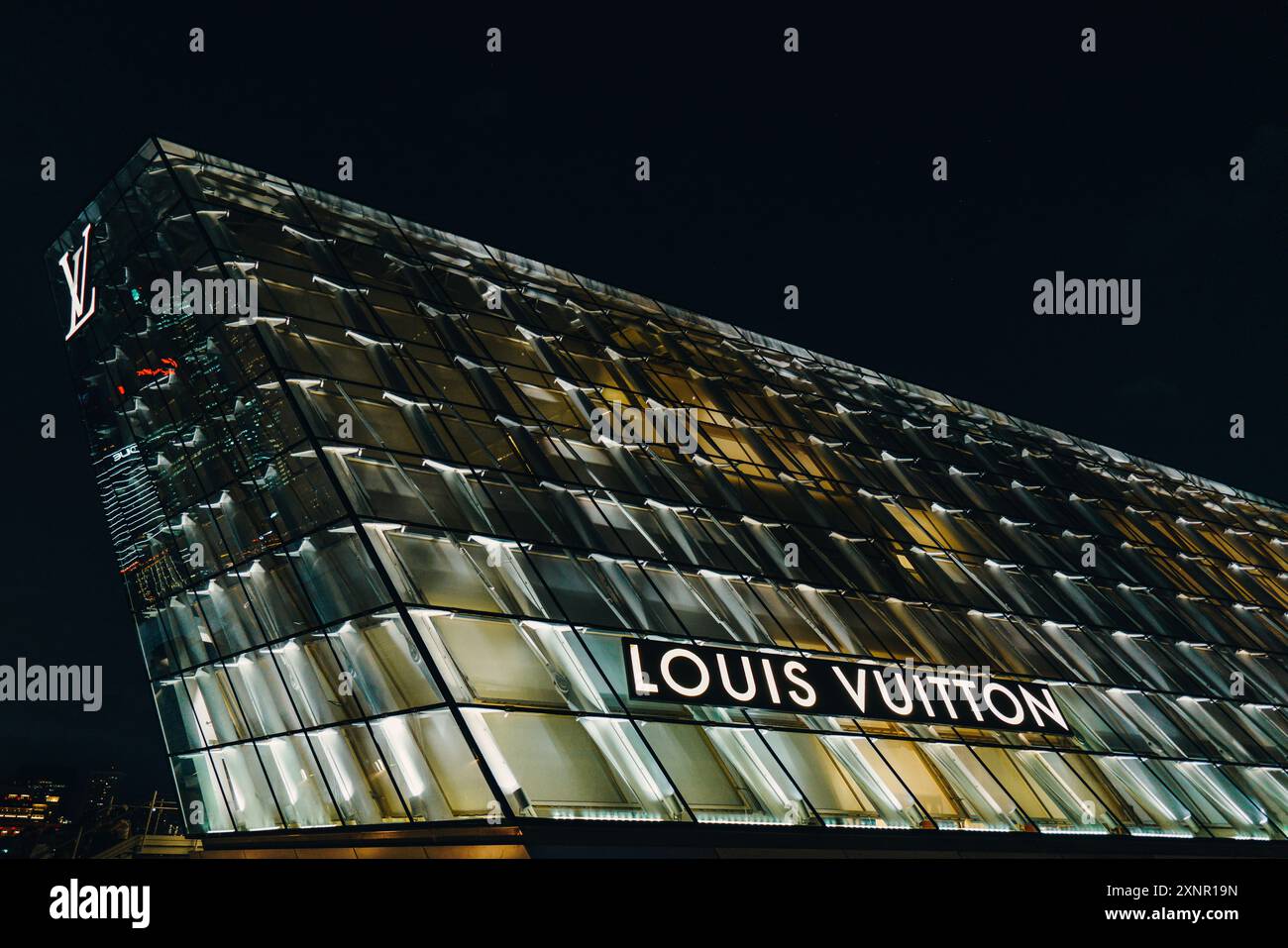Illuminated Louis Vuitton building at night with modern architecture ...