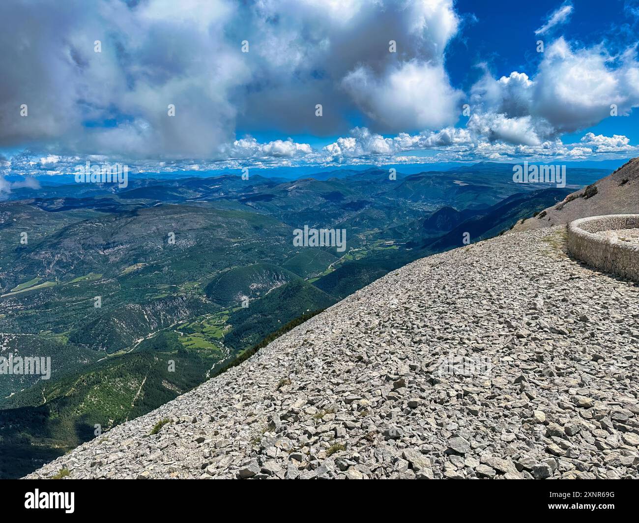 A VIEW OF A VAST VALLEY FROM THE TOP OF MONT VENTOUX WITH A CLOUDY SKY ...