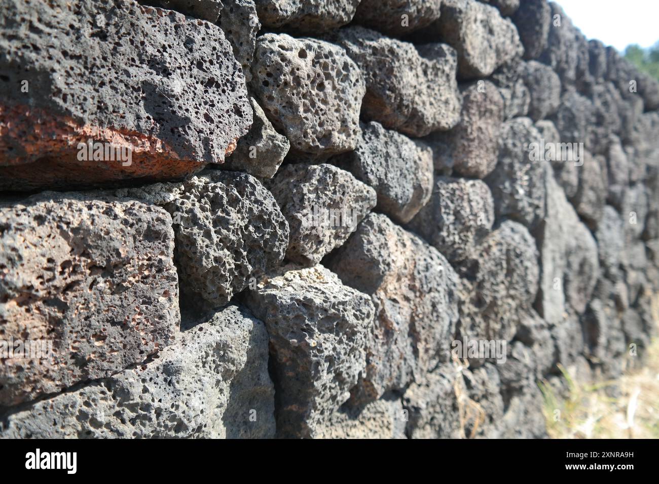 A stone wall background made of basalt stone from Jeju Island, Korea ...