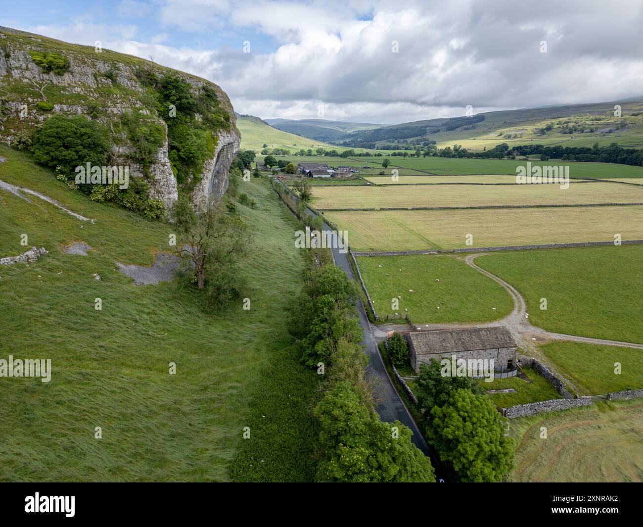 Aerial orbit view of Kilnsey Crag, limestone cliff, Yorkshire Dales ...