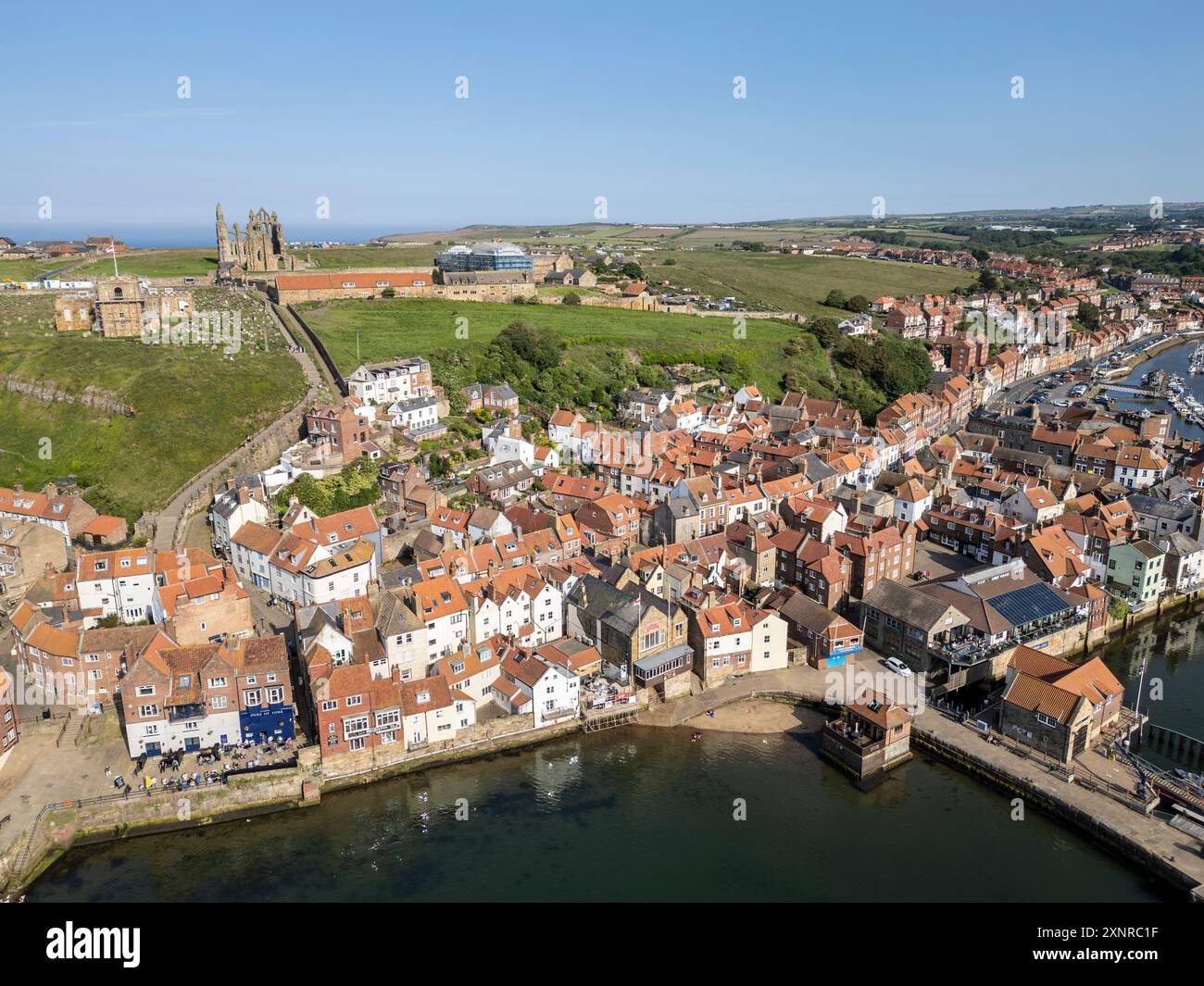 Aerial view over Whitby Old Town buildings with the abbey on the hill ...