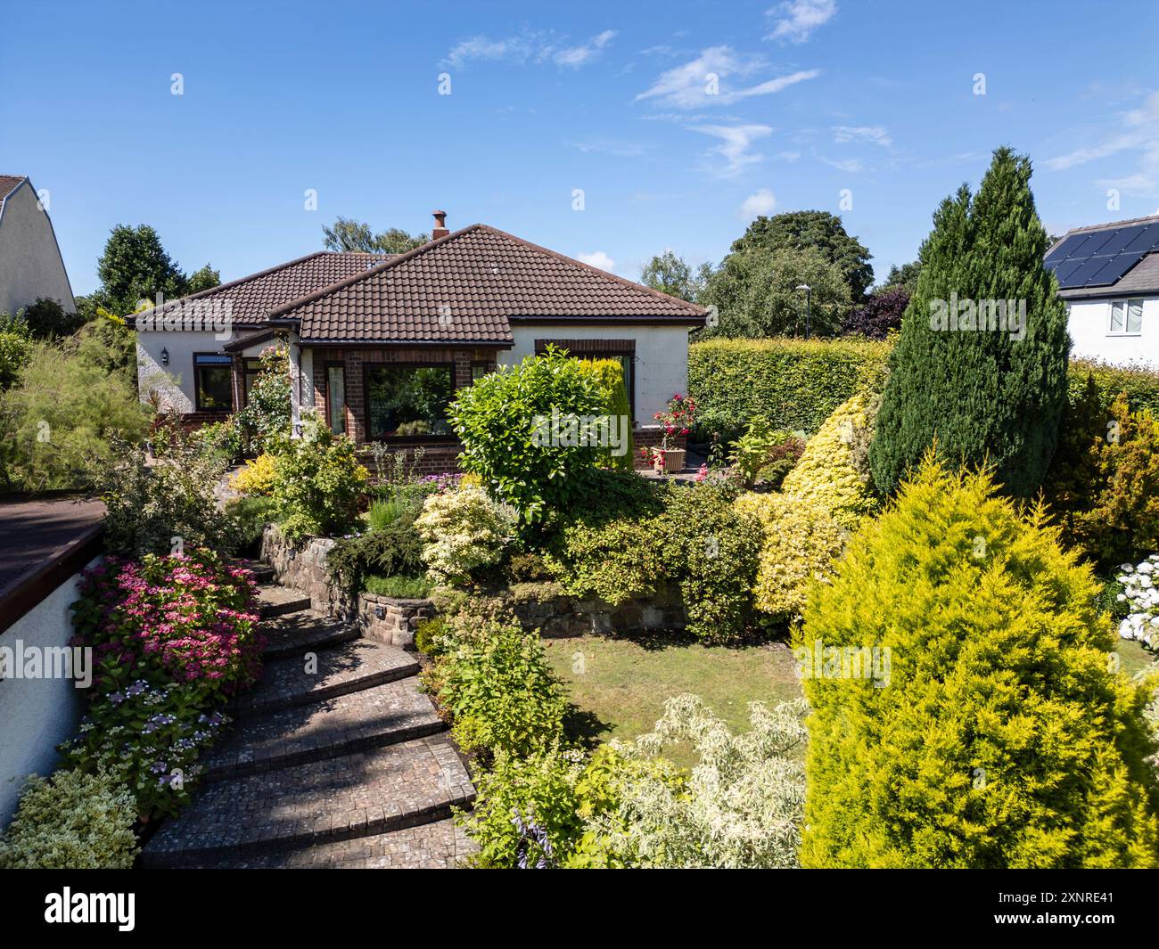Suburban bungalow and front garden on a suuny day in Wirral, England ...