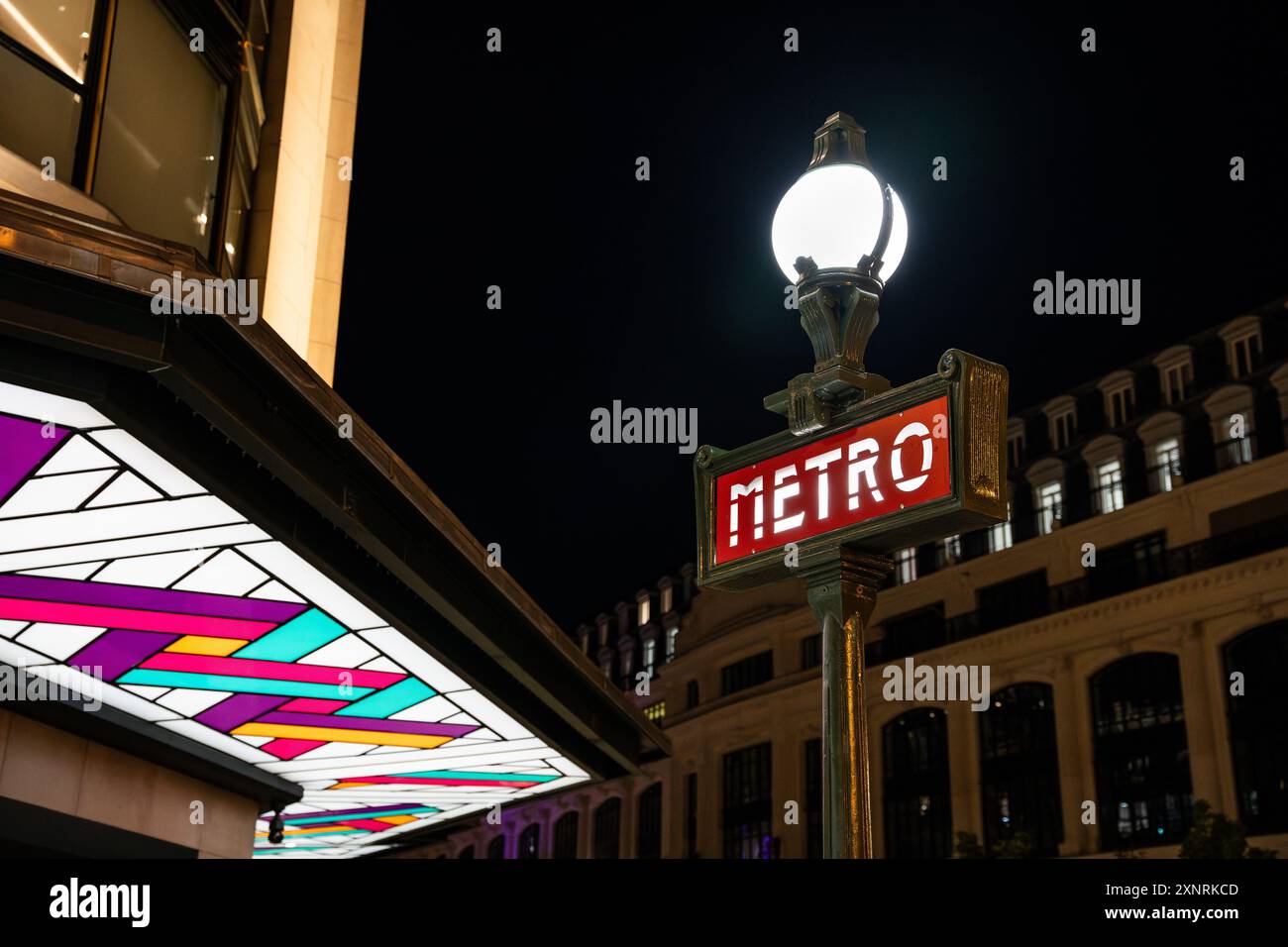 Vintage "Metro" (subway) red sign and globe street lamp post with light ...