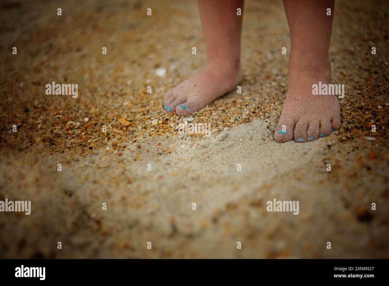 Toddler toes in sand with bright blue nail polish Stock Photo - Alamy