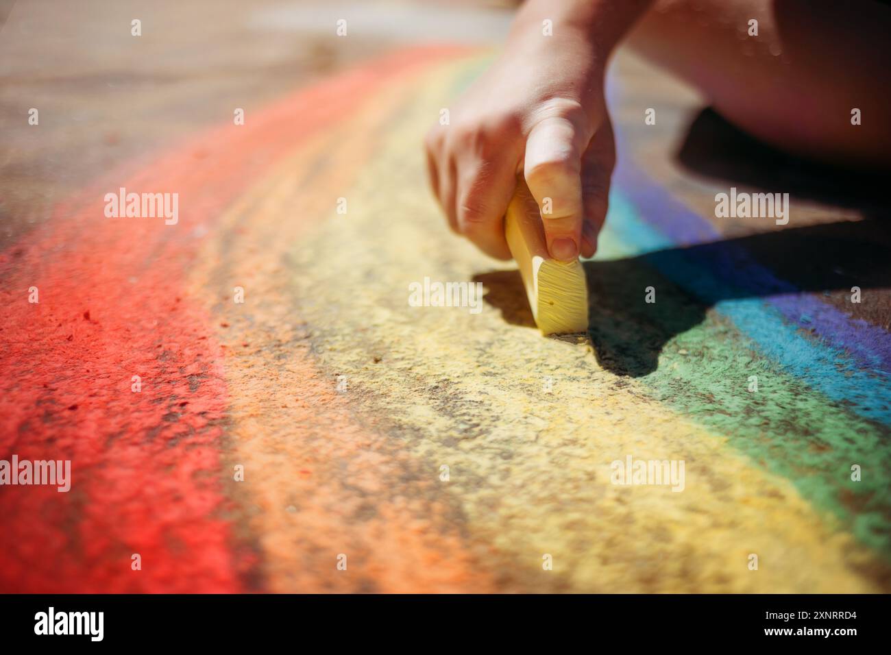 Young Child playing with sidewalk chalk outdoors Stock Photo - Alamy