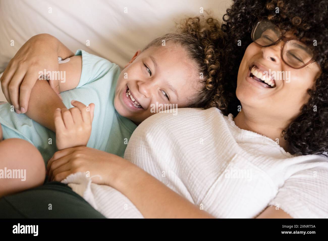 Sisters laughing together on bed Stock Photo - Alamy