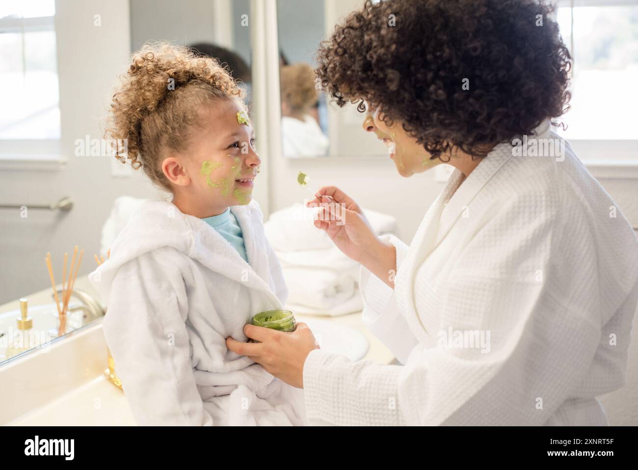 Big sister is putting face mask on little sisters face Stock Photo - Alamy