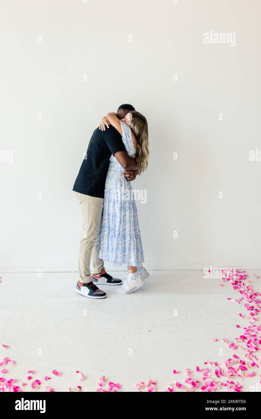 Couple hugging in a room with pink flower petals on the floor Stock ...