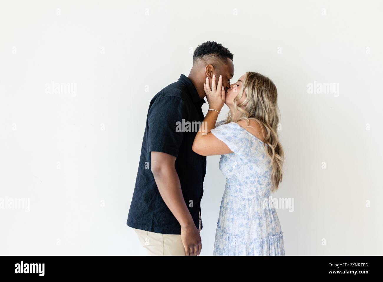 Couple sharing a kiss, woman holding man's face gently, smiling Stock ...