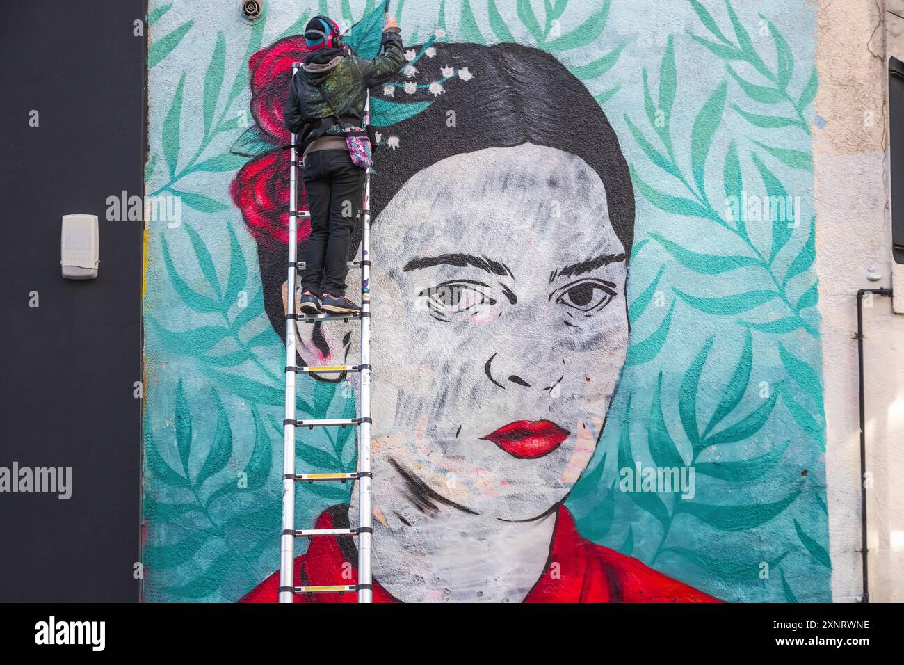 London, UK - January 25, 2024 - A mural artist working on a portrait of ...