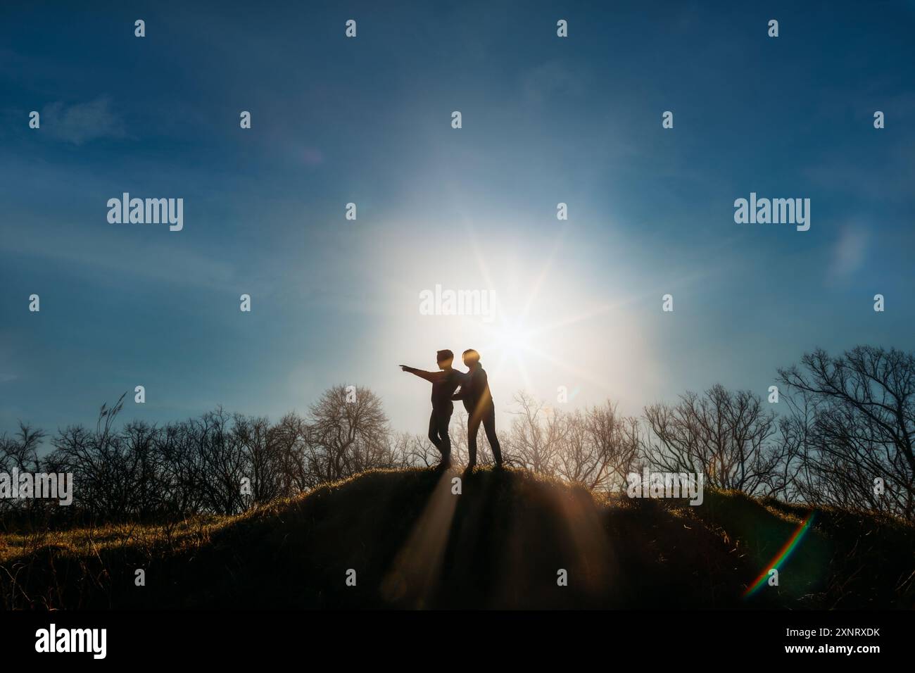 Silhouette of two children pointing out into the distance Stock Photo ...