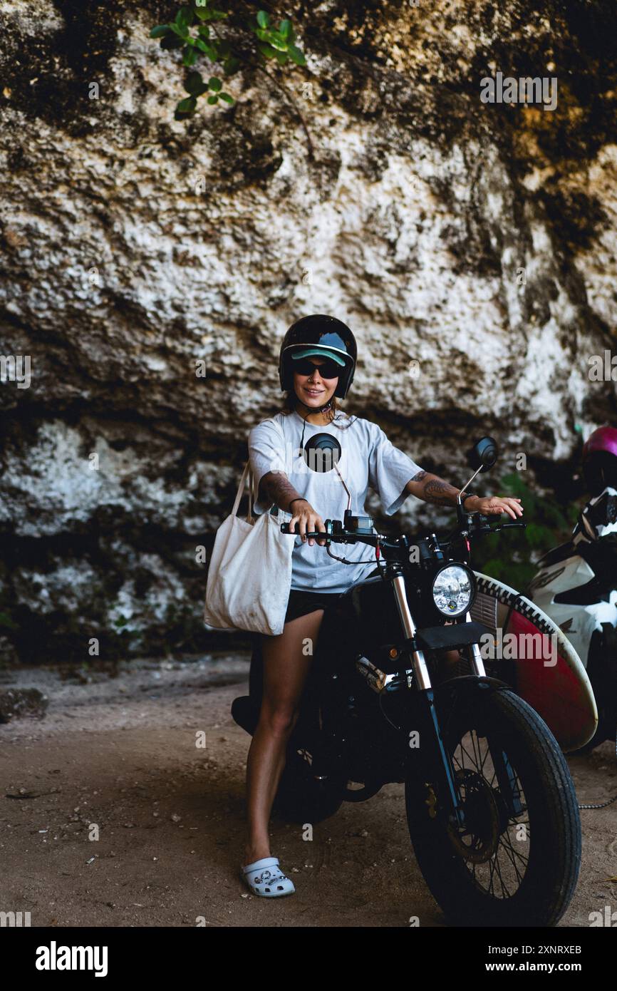 Young woman on custom motorcycle with a surfboard on the racks. Bali ...