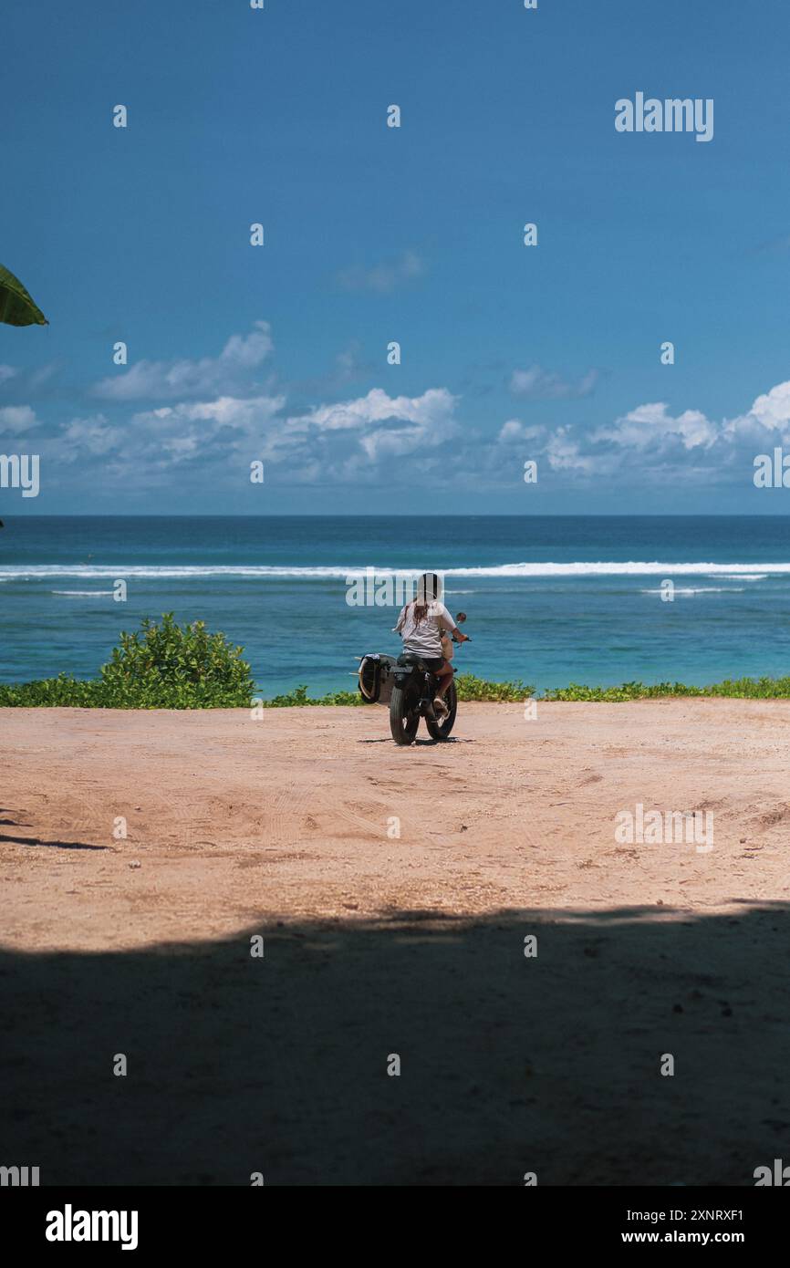 Young woman on custom motorcycle with a surfboard on the racks. Bali ...