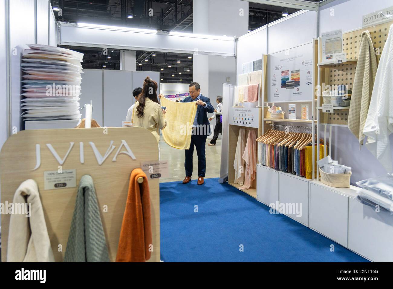 A customer is seen checking a bath towel at the booth of Jviva, a ...
