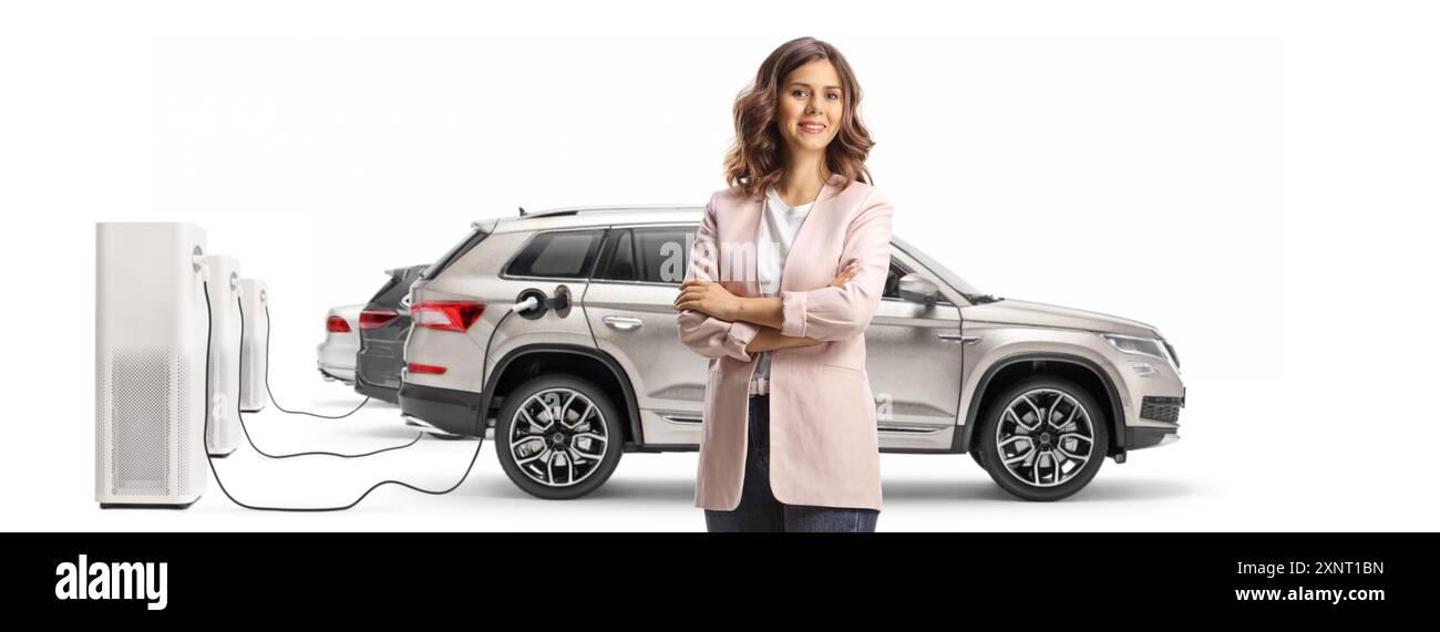 Young female driver posing at ev charging point isolated on white ...