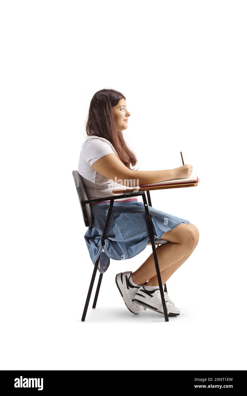 Teenage female student sitting in a school chair and listening isolated ...
