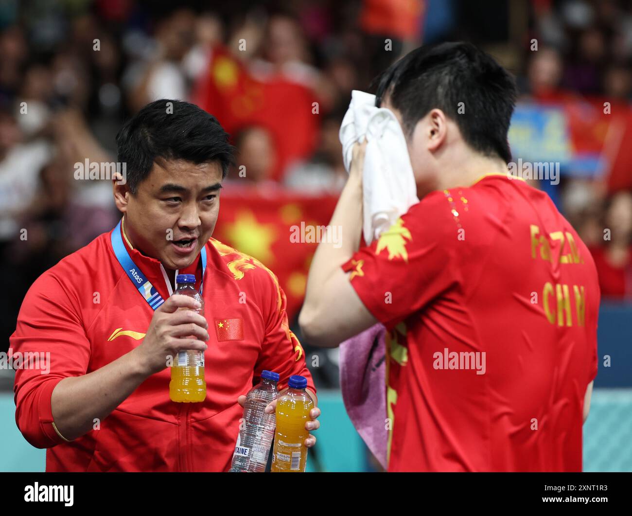 Paris, France. 2nd Aug, 2024. Coach Wang Hao (L) instructs Fan Zhendong of China during the men ...