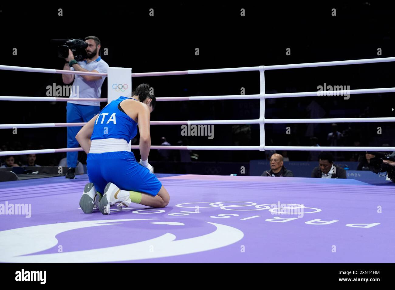 Italy's Angela Carini kneels in the ring after abandoning her fight ...