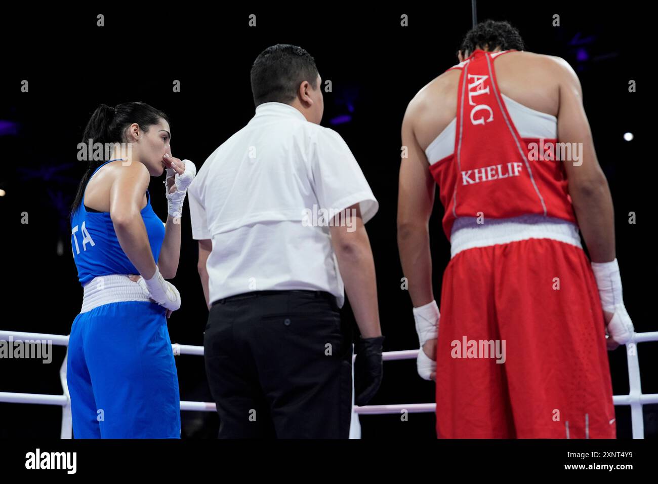 Italy's Angela Carini, left, holds her nose after abandoning her fight ...