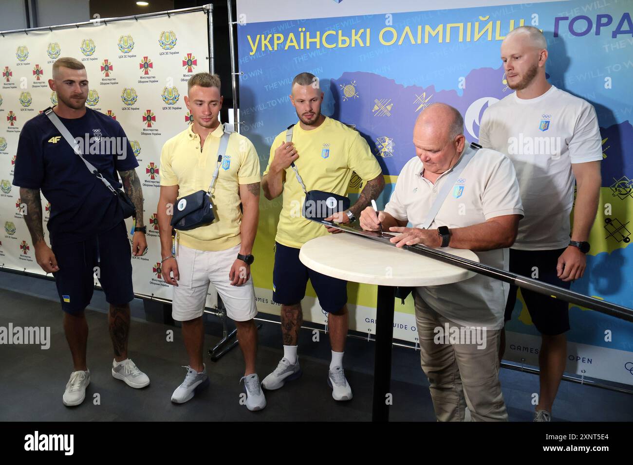 KYIV, UKRAINE - AUGUST 1, 2024 - Senior canoeing coach Oleksandr Simonov (front) signs an oar in ...