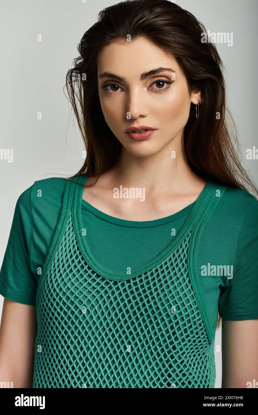 A young woman poses in a stylish green mesh top Stock Photo - Alamy