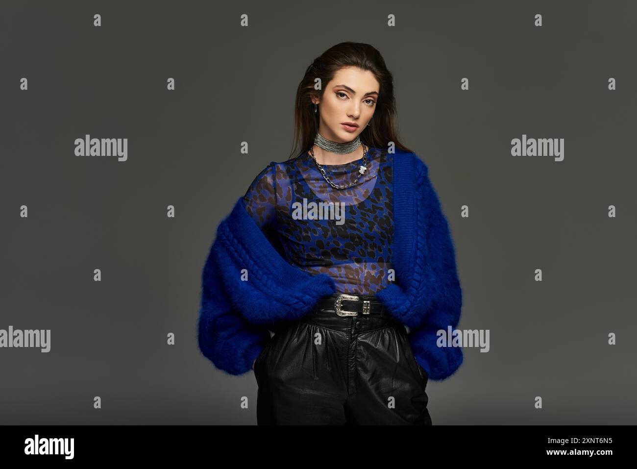 A young woman in a blue cardigan poses against a grey background Stock ...