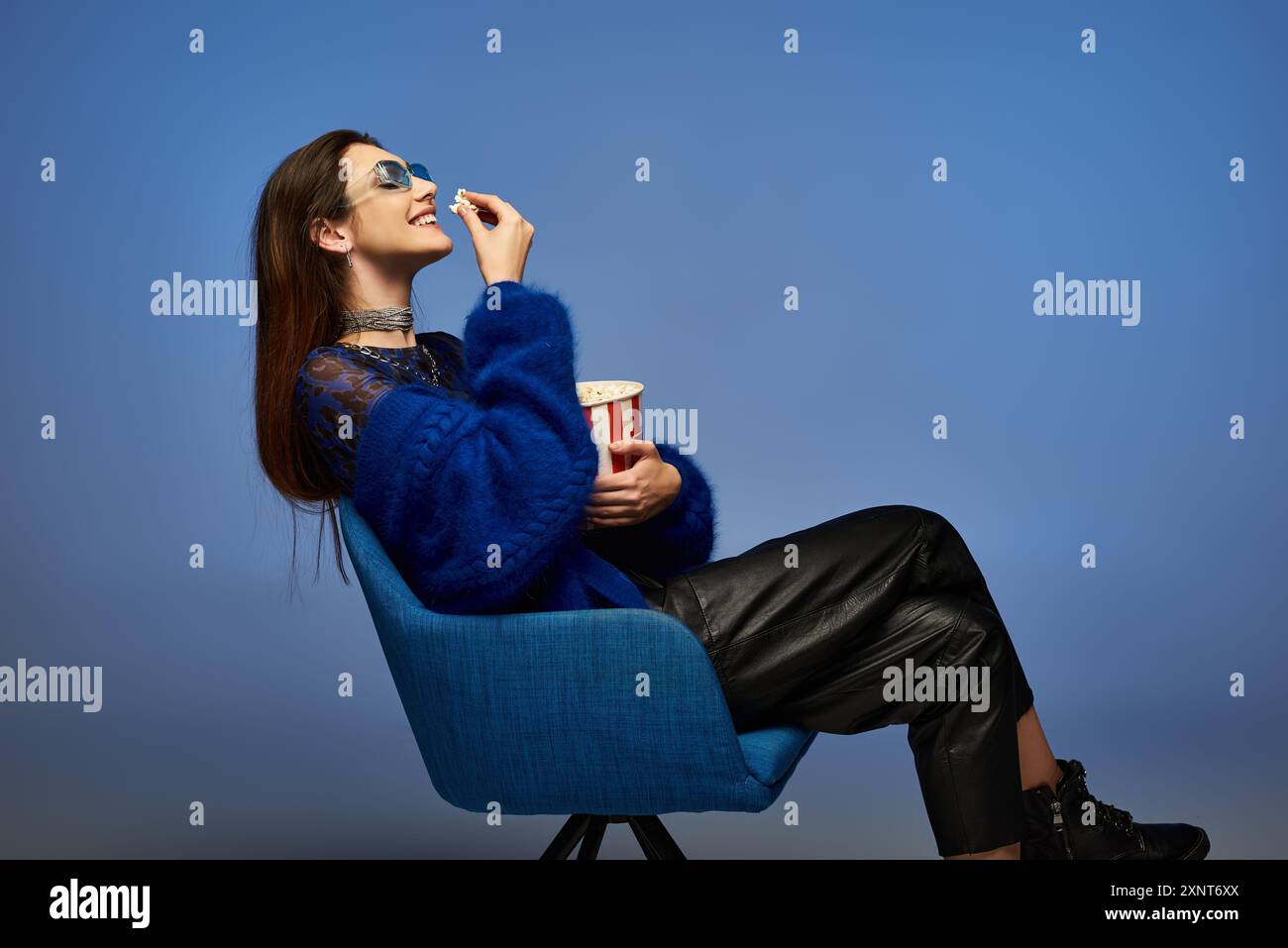 A young woman enjoys a movie, snacking on popcorn Stock Photo - Alamy