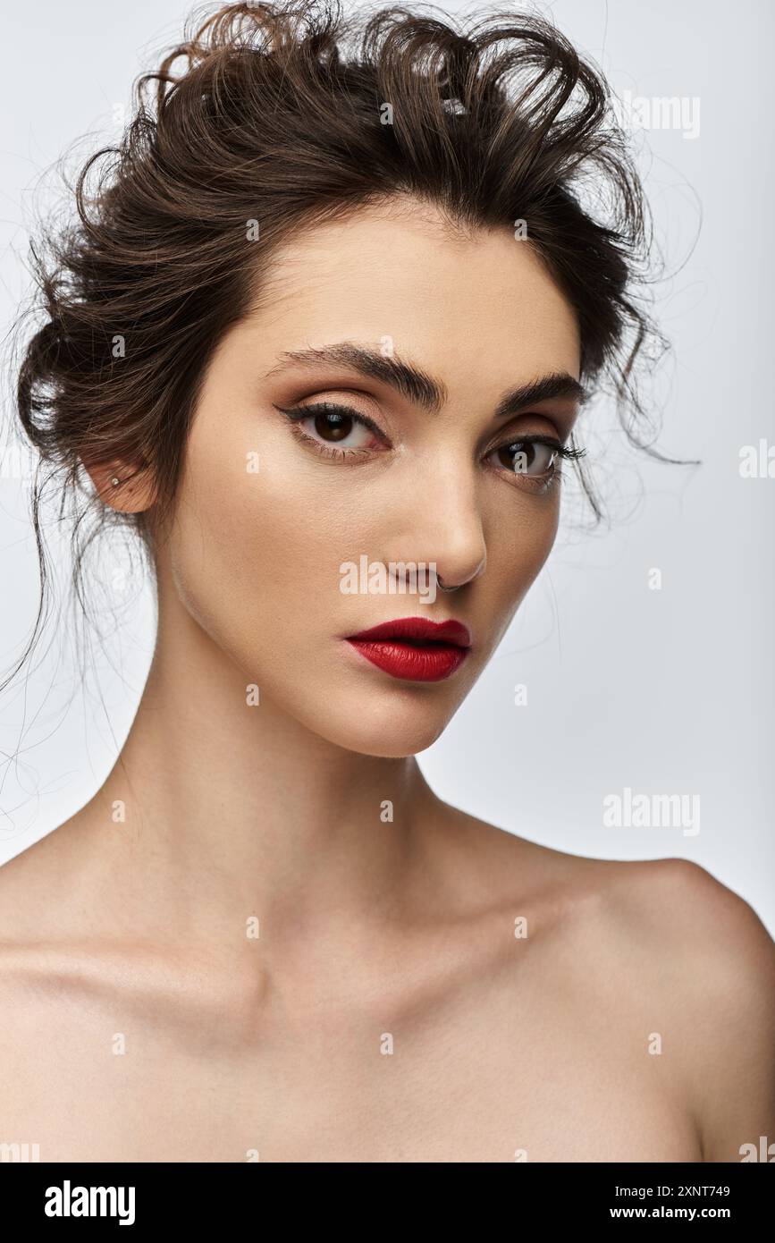 A young woman with elegant features and dark hair stares intently into ...