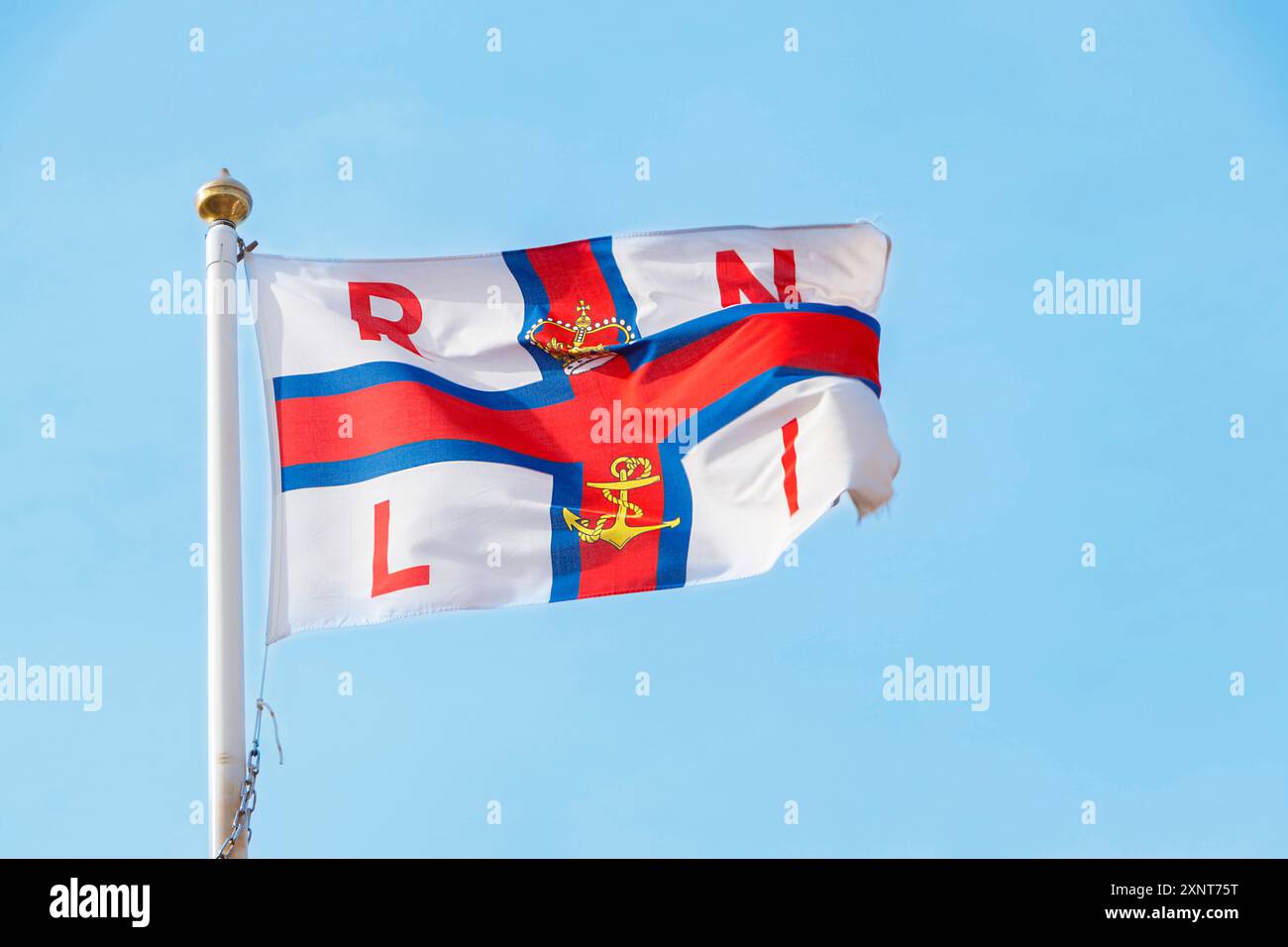 RNLI flag flying in the breeze Amble harbour Northumberland UK Stock ...