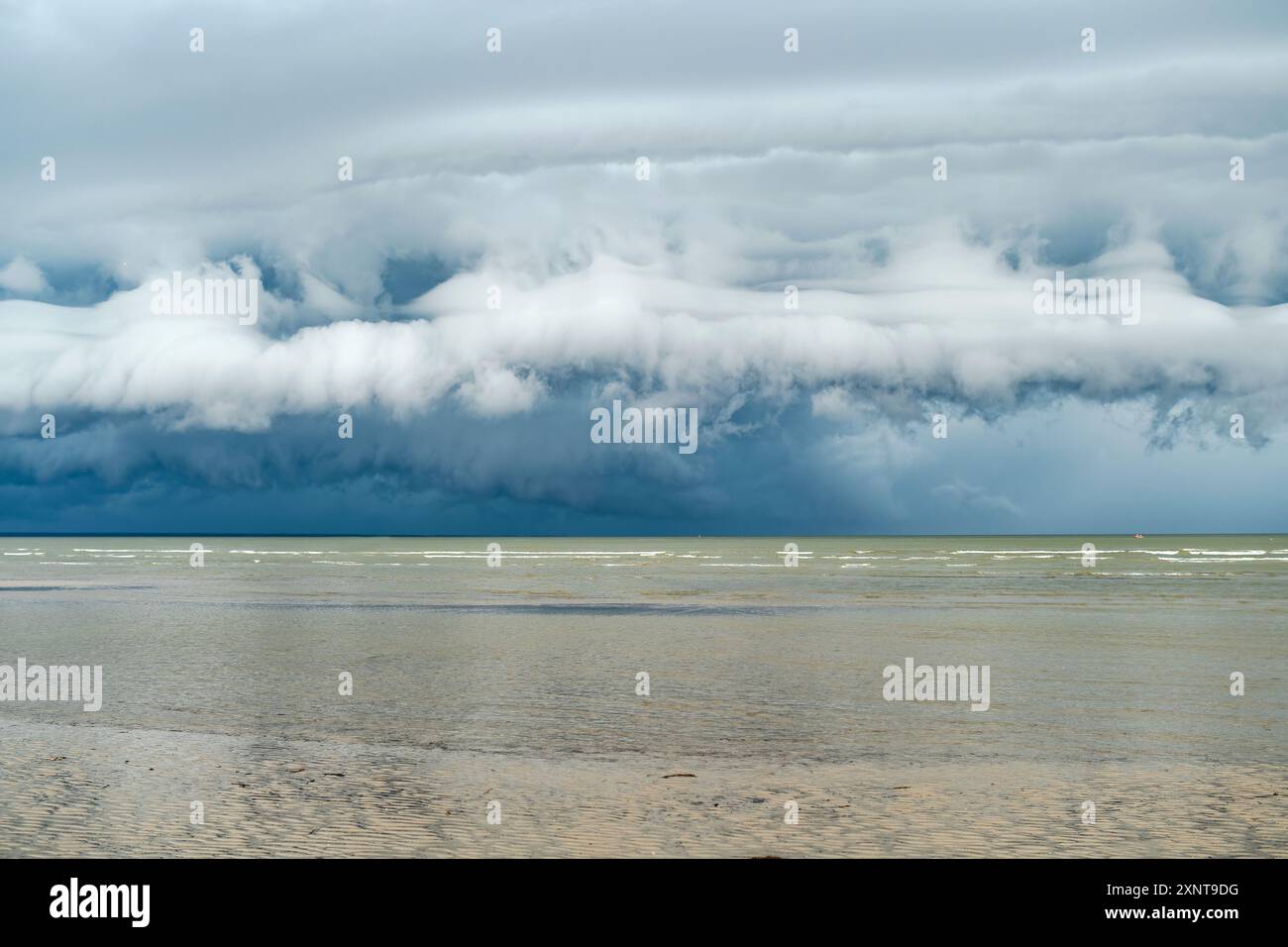 Storm clouds forming over a beach. Dense, towering raincloud before the ...
