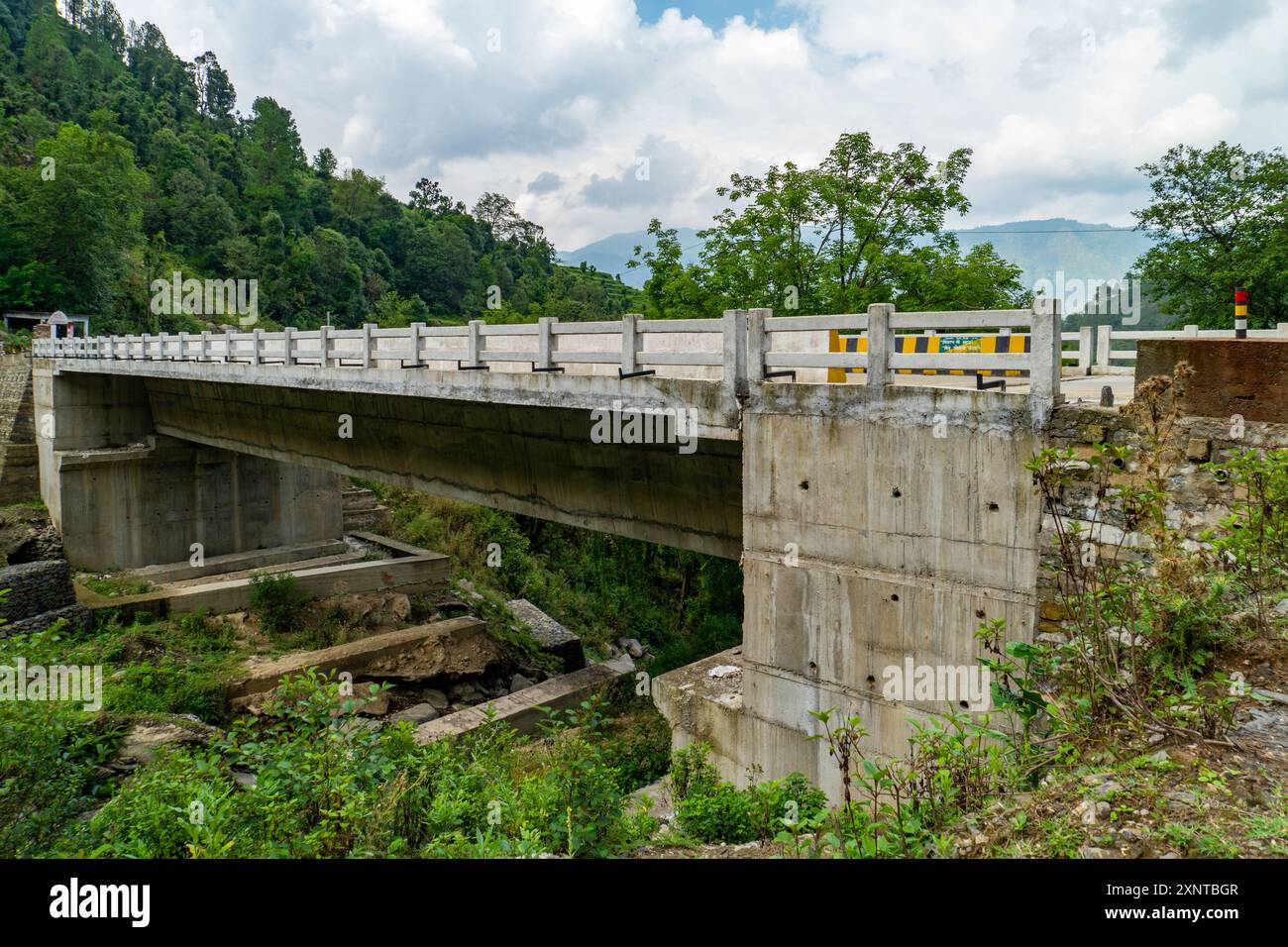 A concrete solid slab bridge connecting two small hills at the base in ...