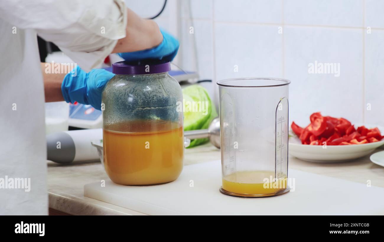 Chef in professional white kitchen make sweet sause with honey and ...