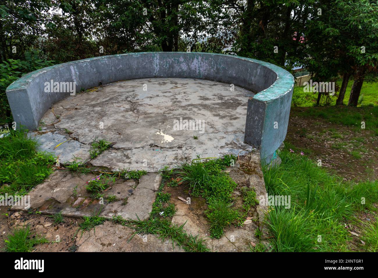 A circular concrete sitting area and bird-watching structure set amid ...