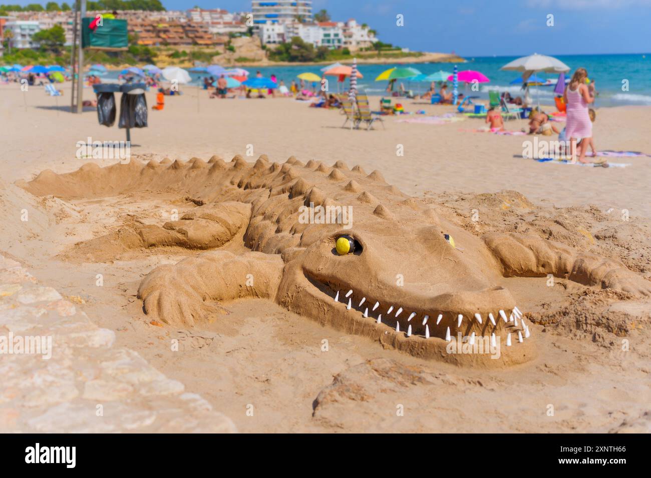 Engaging beach atmosphere with a giant sand crocodile on display Stock ...