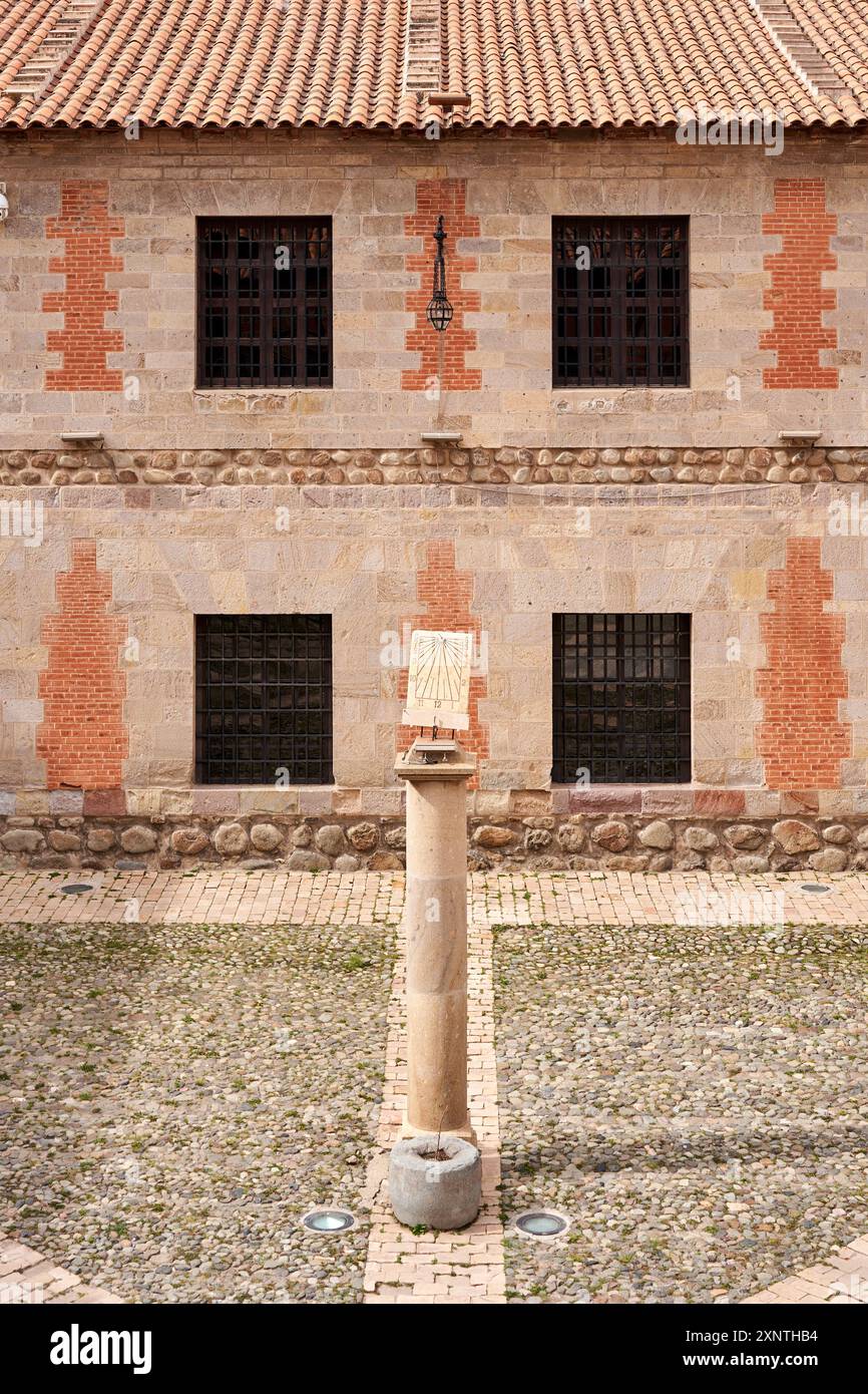 A historic courtyard featuring a sundial on a pedestal, surrounded by a ...